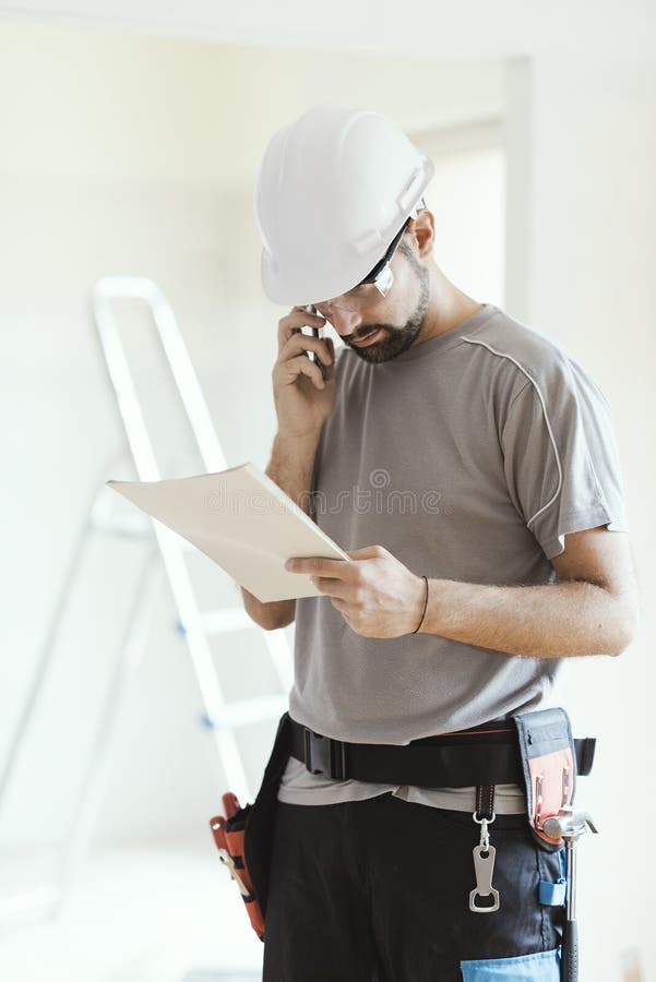 Professional Construction Worker Checking a Project and Calling Stock ...