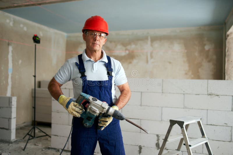 Professional Construction Worker in Uniform Standing with Rotary Hammer ...