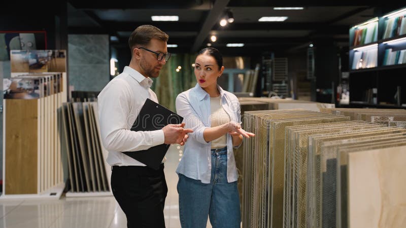 Consultant Advising Customer Choosing Tiles in Hardware Store Stock ...