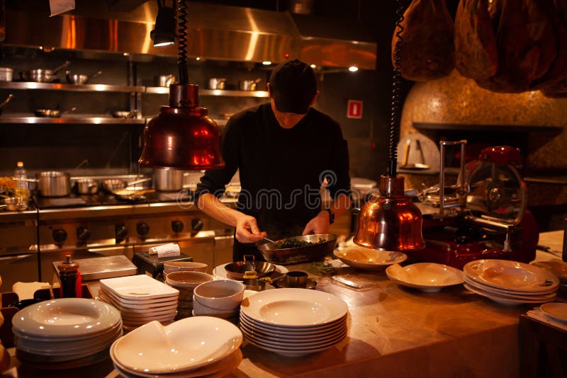 Professional Cook. Chef in Black Apron and Cap Working in Restaurant ...