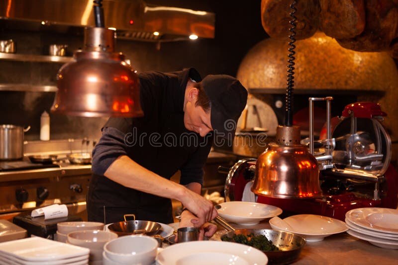 Professional Cook. Chef in Black Apron and Cap Working in Restaurant ...