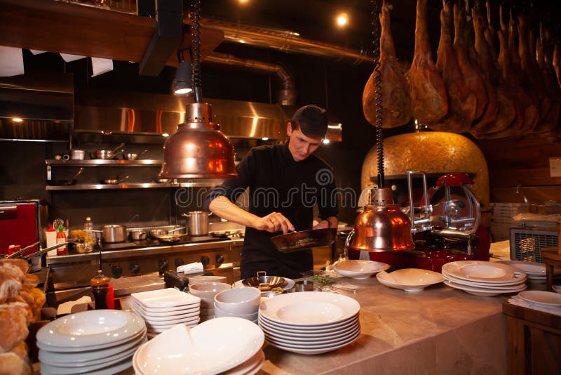 Professional Cook. Chef in Black Apron and Cap Working in Restaurant ...