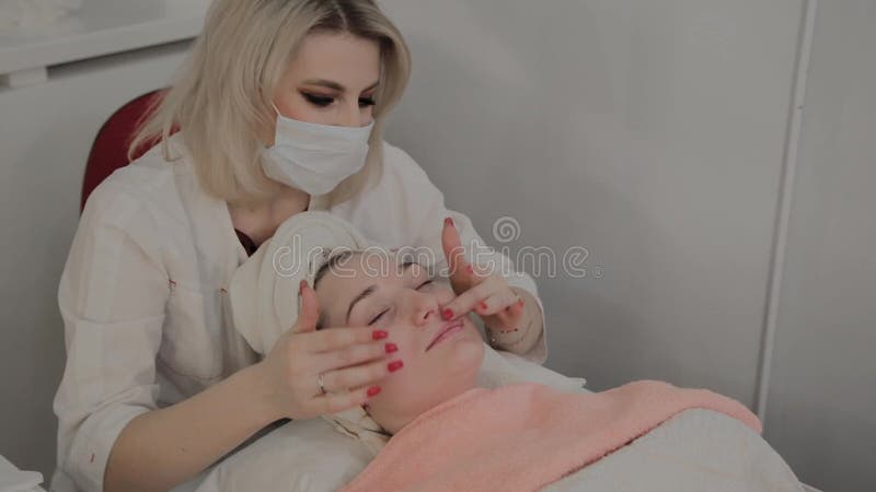 A Professional Cosmetologist Does A Face Massage Procedure Before