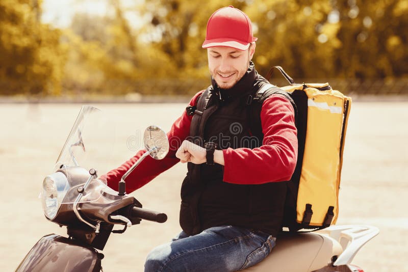 Professional Courier Checking Time on Watch Sitting on Scooter Outside ...