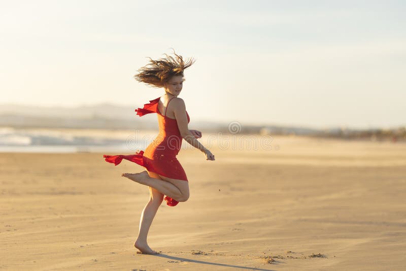 Dancer Performing on Sandy Beach at Sunset: Graceful Movement and ...