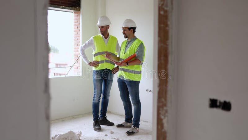 Construction Engineer Discussing with Architect Worker at Indoor ...