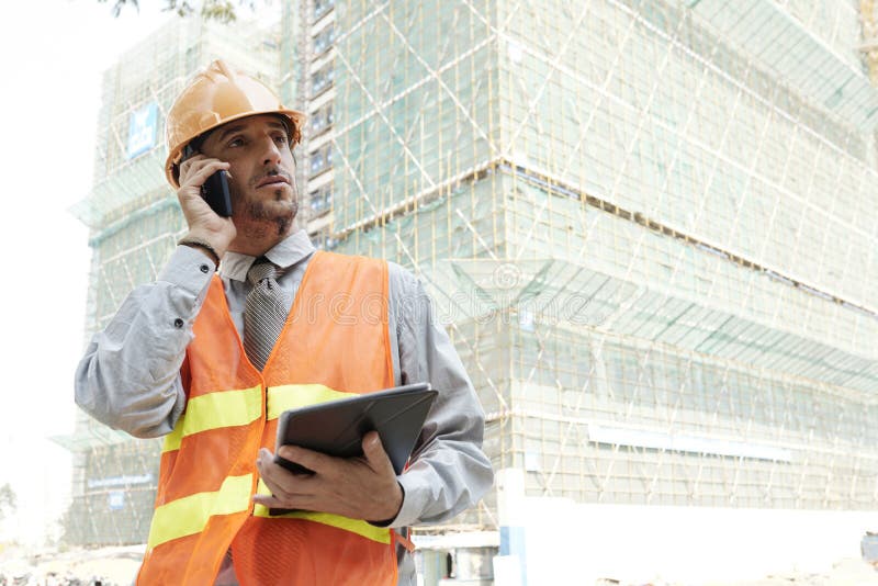 Engineer calling coworker stock image. Image of device - 139978791