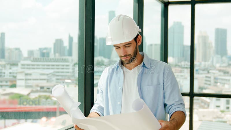 Professional Engineer Look at City View while Holding Project Plan ...