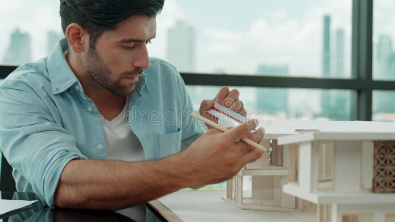 Skilled Engineer Looking at Blueprint while Measure House Model ...