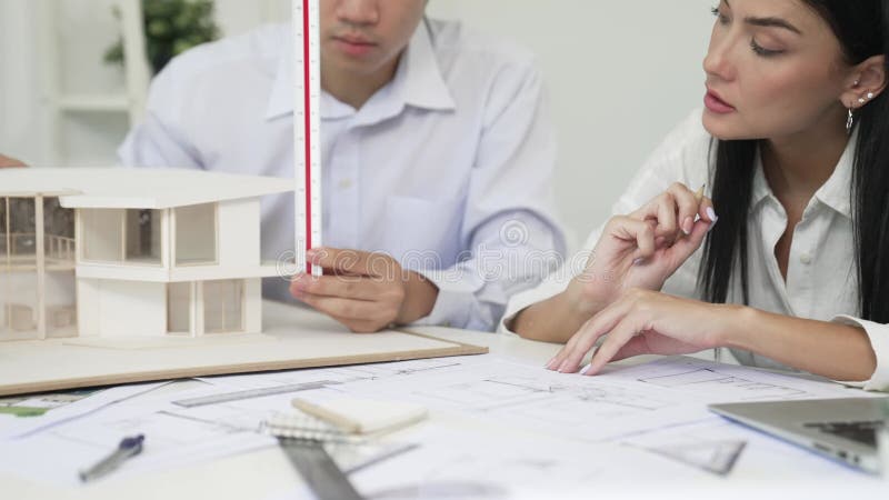 Engineer Measures Model while Skilled Designer Writes at Blueprint ...