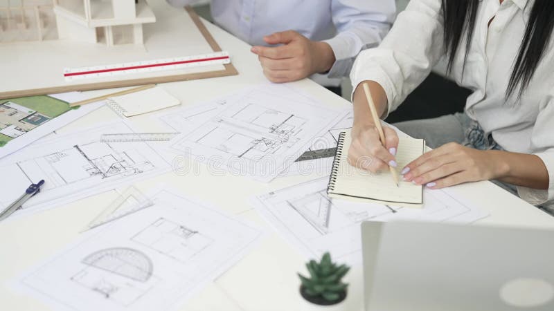 Engineer Measures Model while Skilled Designer Writes at Blueprint ...