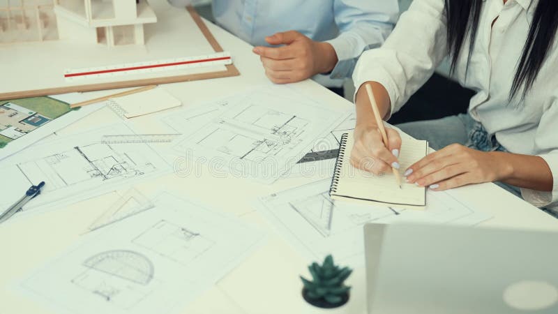 Engineer Measures Model while Skilled Designer Writes at Blueprint ...