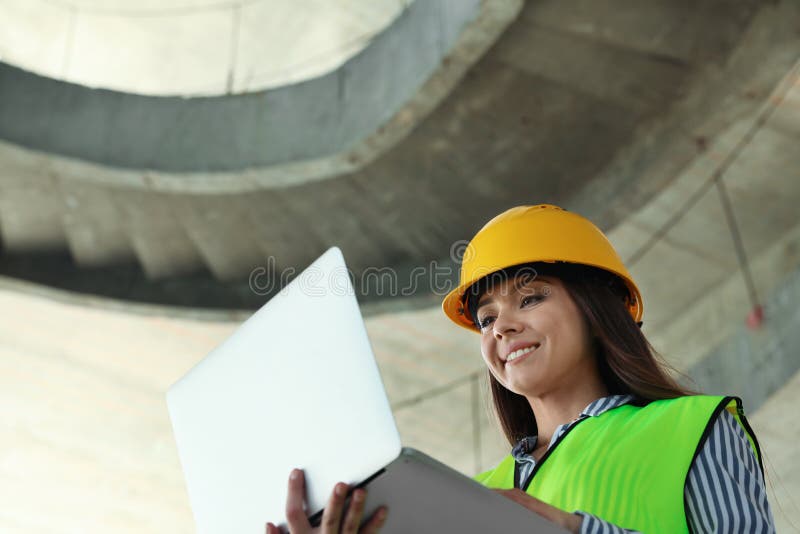 Professional Engineer in Safety Equipment with Laptop at Construction ...