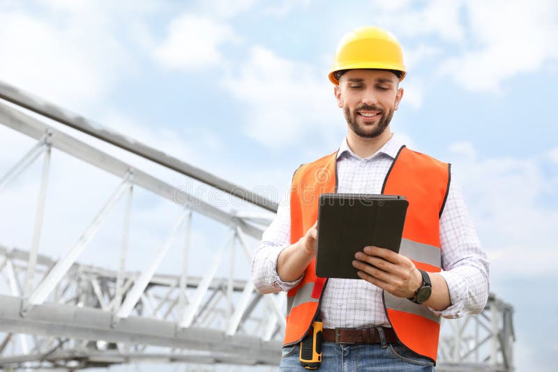 Professional Engineer with Tablet Near High Voltage Tower Construction ...