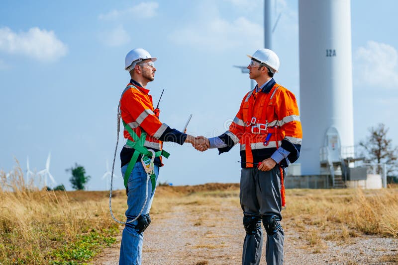 Professional Engineers Technicians Working at Wind Turbine Farm Field ...