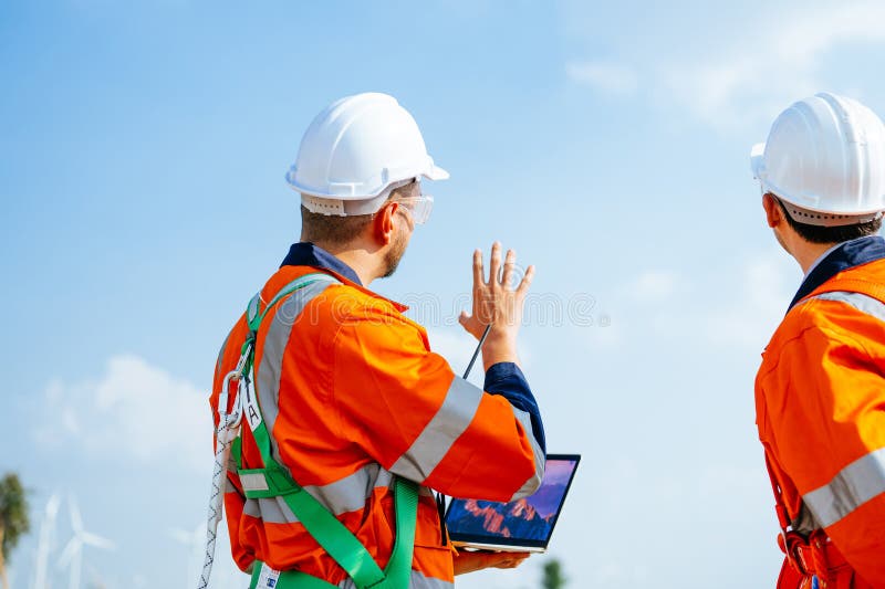 Professional Engineers Technicians Working at Wind Turbine Farm Field ...