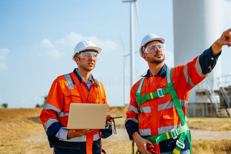 Professional Engineers Technicians Working at Wind Turbine Farm Field ...