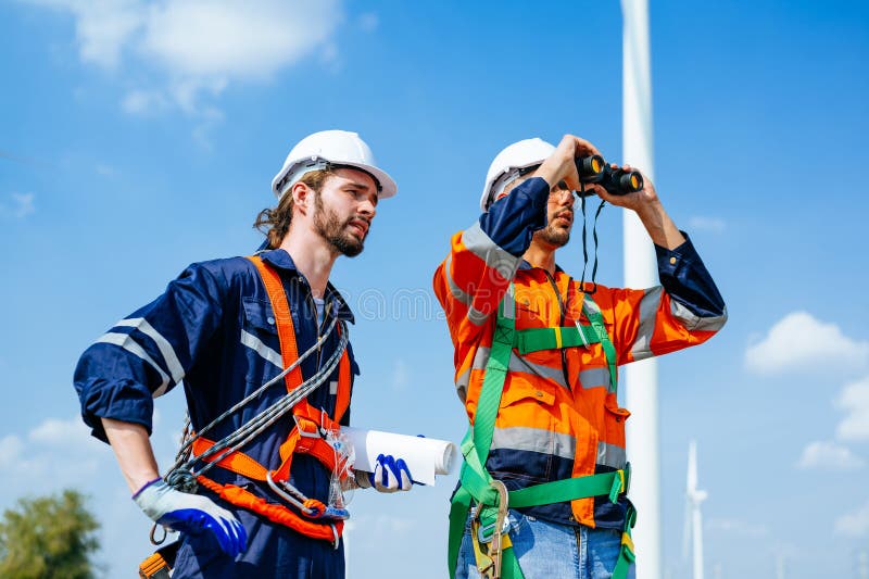 Professional Engineers Technicians Working at Wind Turbine Farm Field ...