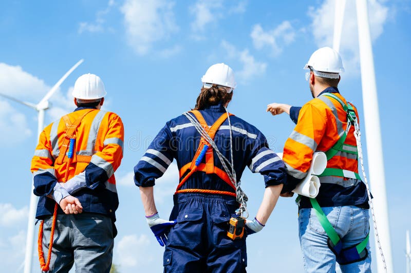 Professional Engineers Technicians Working at Wind Turbine Farm Field ...