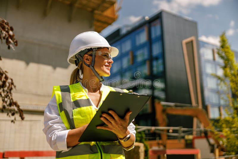 Professional Female Engineer in Protective Helmet Making Notes on ...