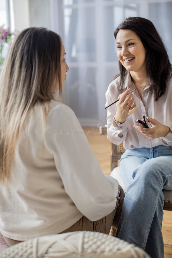 Professional Female Makeup Artist Applying Cosmetics On Model Face Use