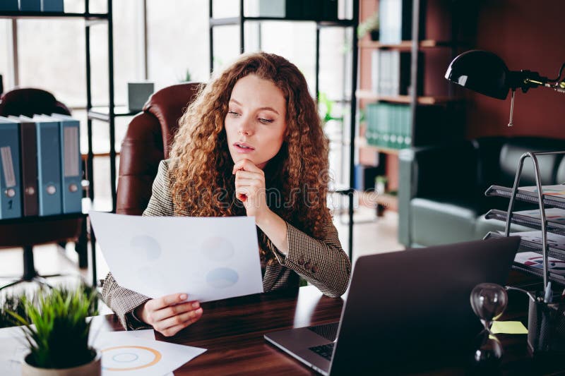 Successful Young Businesswoman Analyzing Professional Documents in ...