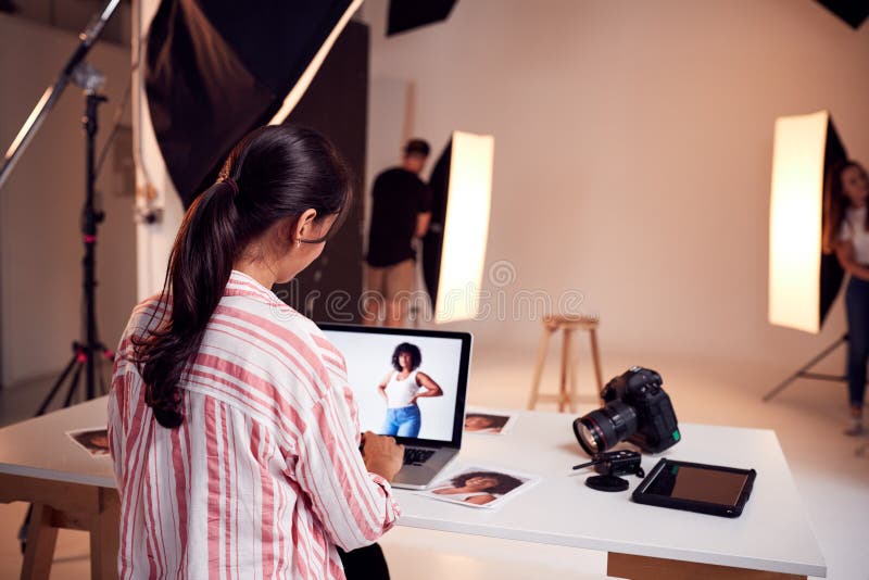 Professional Female Photographer Working in Studio with Assistants in ...