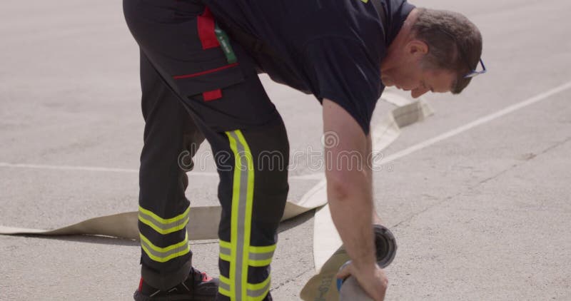 A Professional Firefighter is Seen Diligently Cleaning and Storing Fire ...