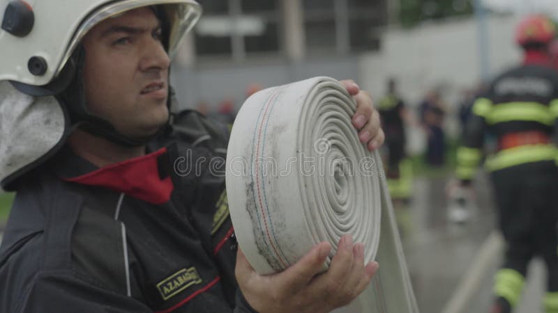 A Professional Firefighter is Seen Diligently Cleaning and Storing Fire ...