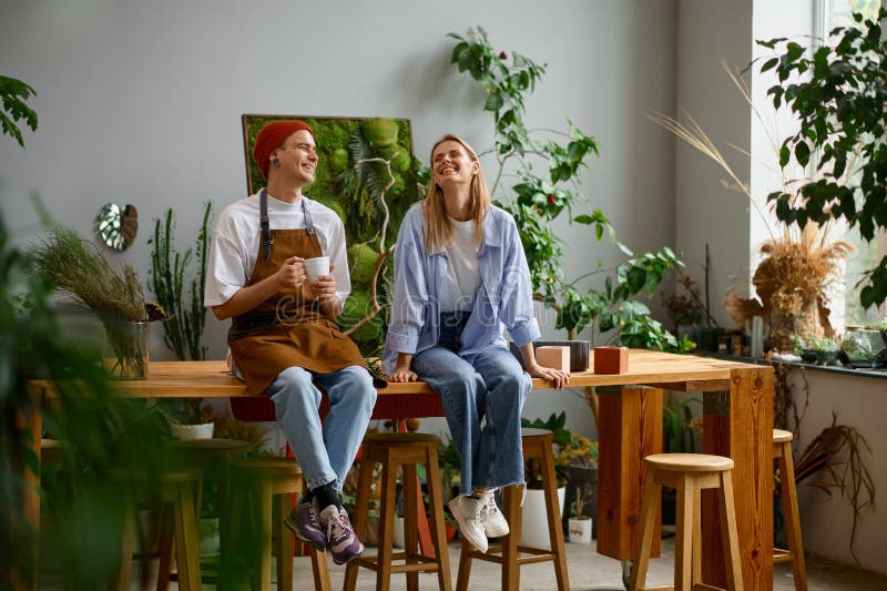 Professional Floral Artist Talking and Smiling Sitting on Table Stock ...