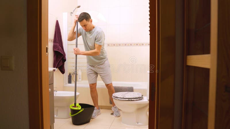 Man Cleaning Bathroom Floor at Home with Mop Stock Photo - Image of ...