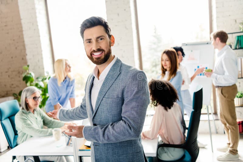 Smiling Professional Presenting in a Dynamic Workspace with a Diverse ...