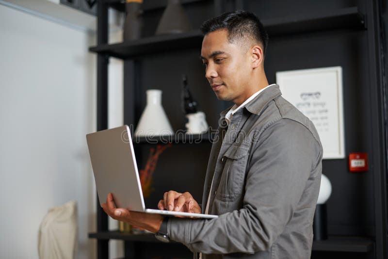 Professional Individual Using a Laptop in a Modern Office Environment ...