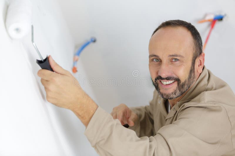 Professional Male Decorator Using Paint Roller Stock Image - Image of ...