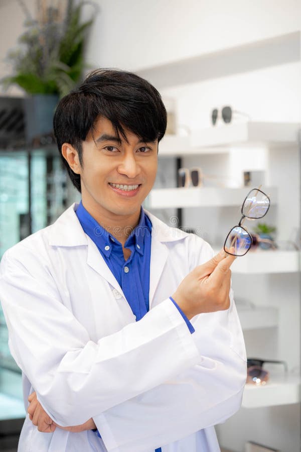 Professional Male Optician Standing and Offering Glasses in Optical ...