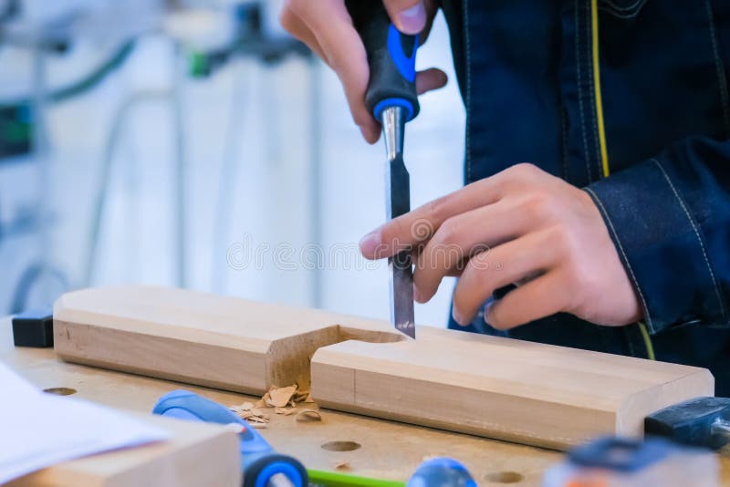 Carpenter Using Chisel To Carve Wood on Rough Workbench at Workshop ...
