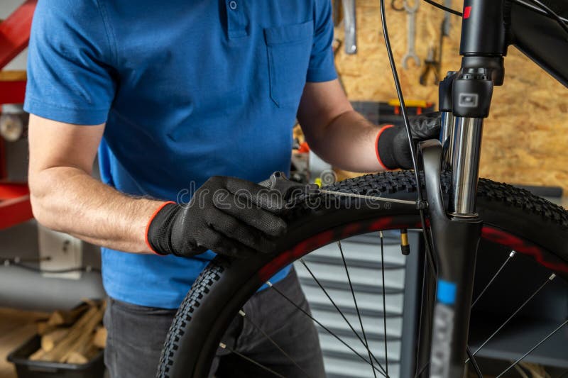 Professional Man Fixing Bike Carefully in Garage Stock Image - Image of ...