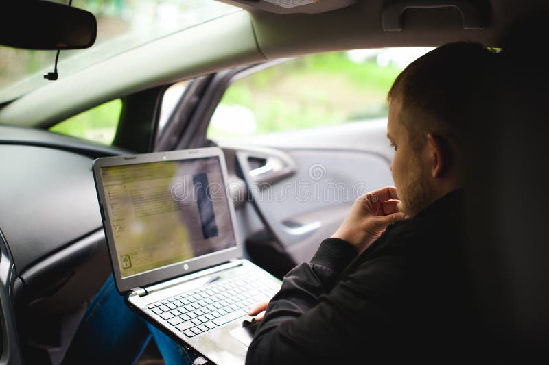 Professional Man with a Laptop in Car Tunes Tuning Control System ...