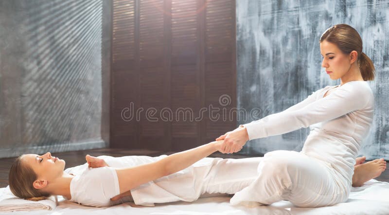 Professional Masseur Doing Thai Massage Therapist Is Making Body Stretching Exercises To The