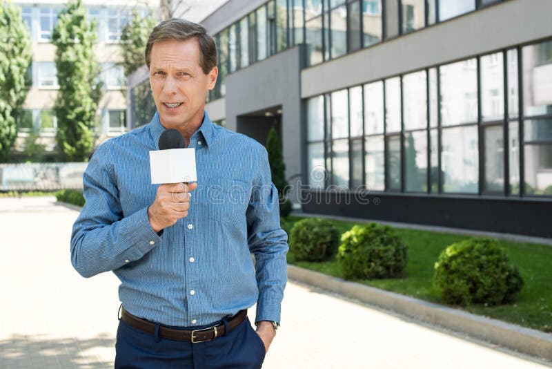 Professional Mature News Reporter Talking with Microphone Stock Photo ...