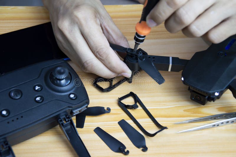 Professional Mechanic Repairing a Drone with a Small Screwdriver on the ...