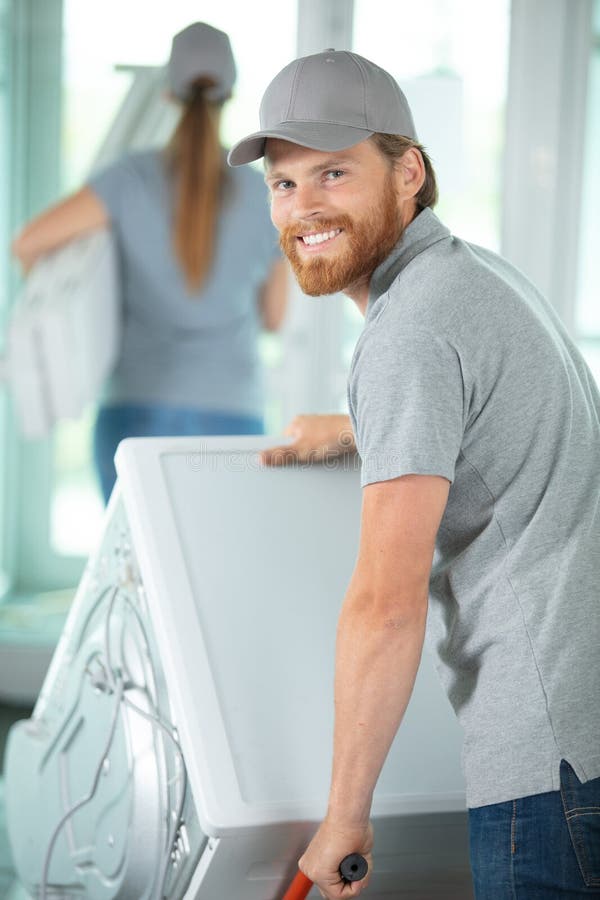 Professional Movers in Uniform Placing Modern Washing Machine Stock ...