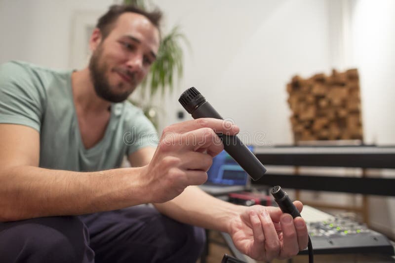 Musician in Home Music Studio Plugging Microphone in and Testing Stock ...