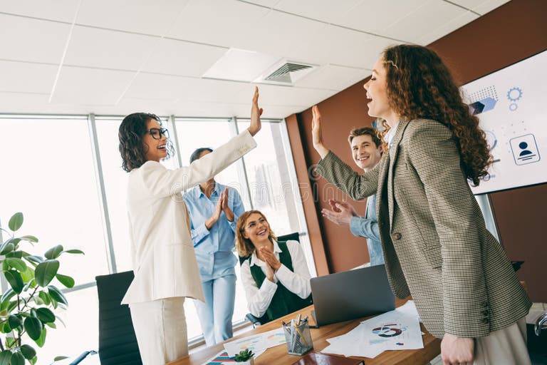 Team Celebrating Success with High-five in Professional Office Setting ...