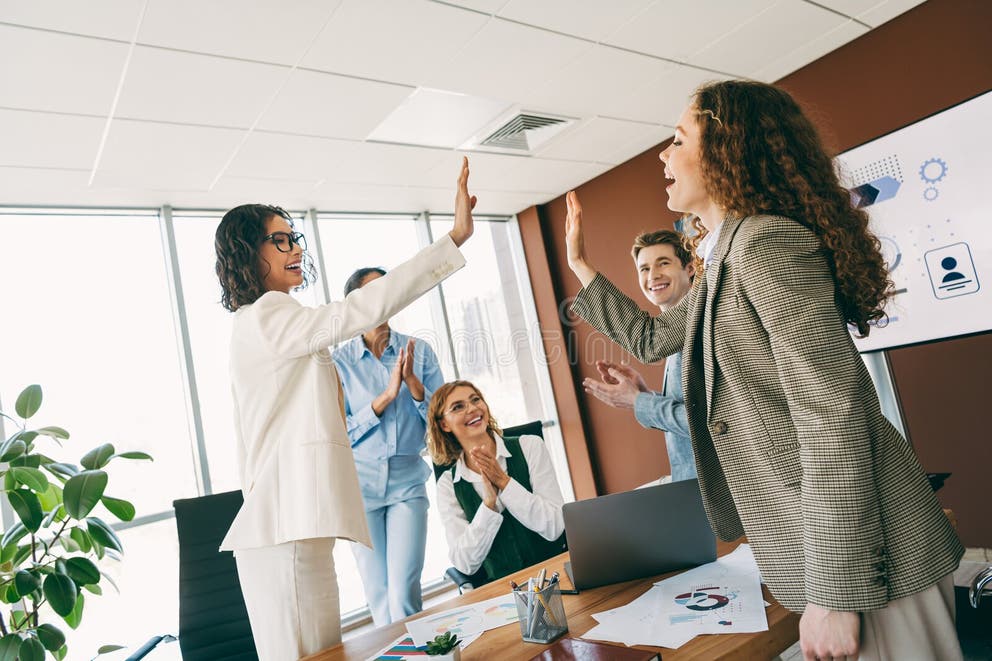 Team Celebrating Success with High-five in Professional Office Setting ...
