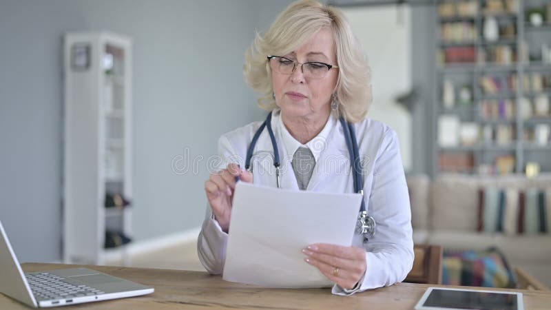 Professional Old Female Doctor Reading Documents Stock Footage - Video ...