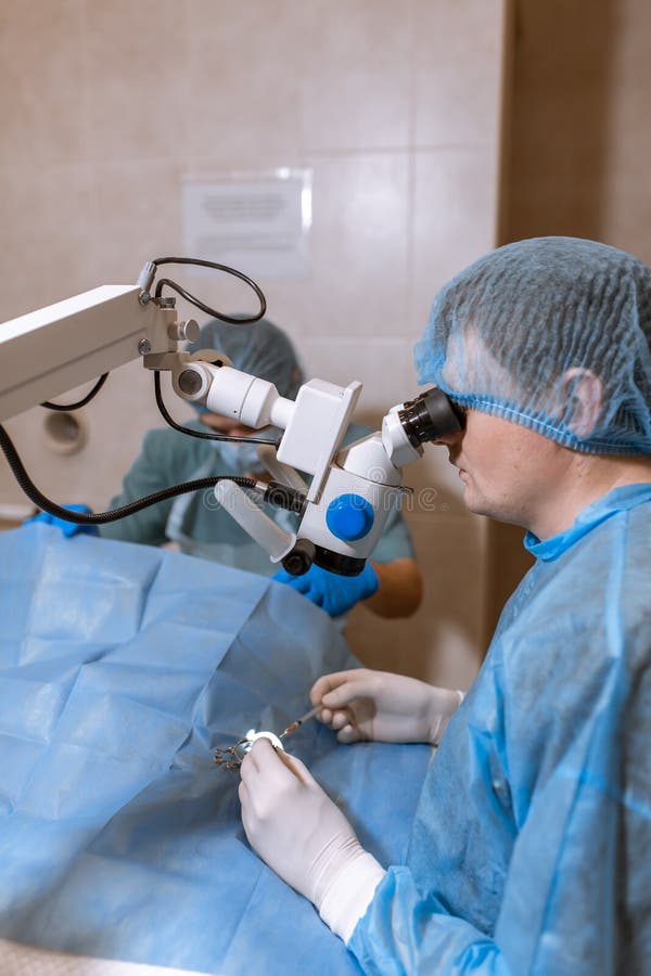 A Professional Ophthalmologist Performs Eye Surgery with a Microscope ...