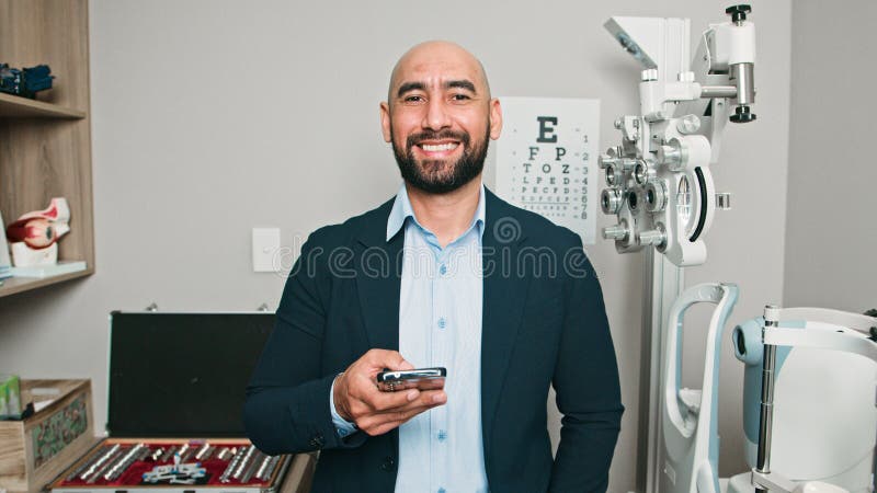 Professional Optometrist Smiling Confidently in an Eye Examination Room ...