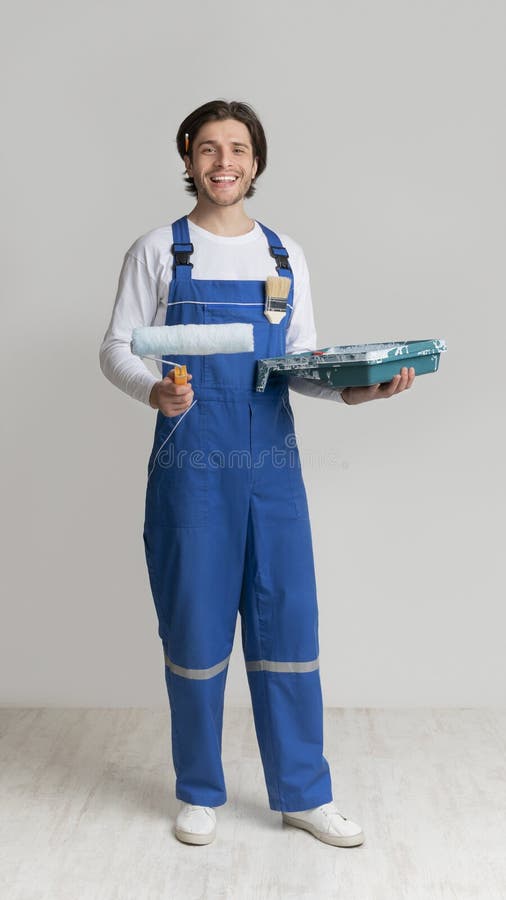 Professional Painter in Work Uniform Holding Paint Roller and Smiling ...