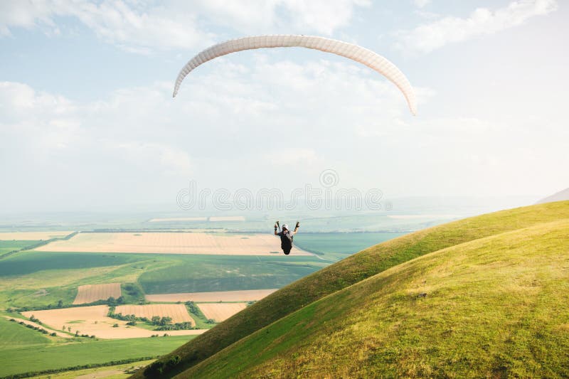 Professional Paraglider in a Cocoon Suit Flies High Above the Ground ...
